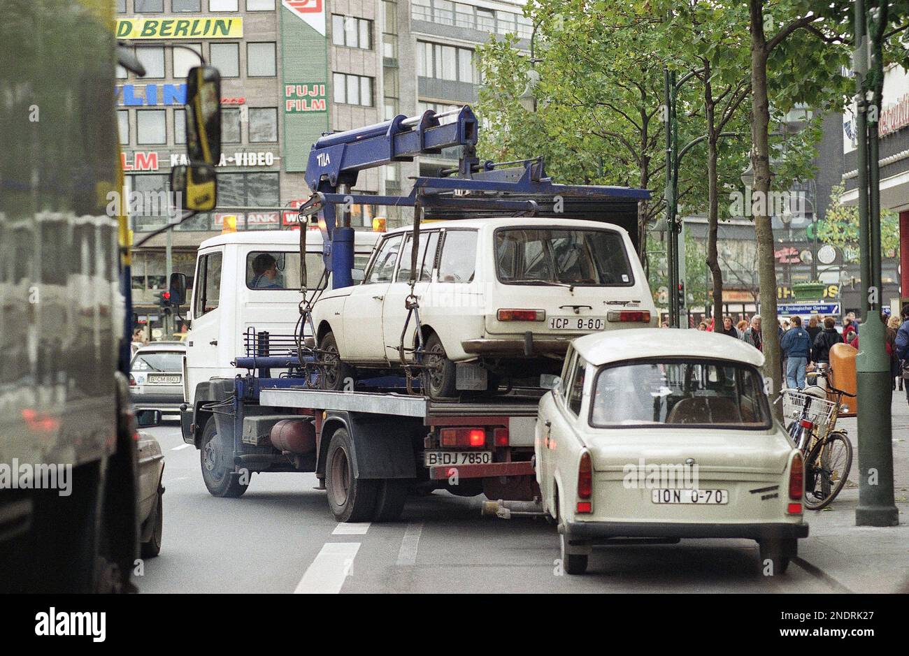 A tow truck, loaded with a Wartburg and towing a Trabant, works to ...