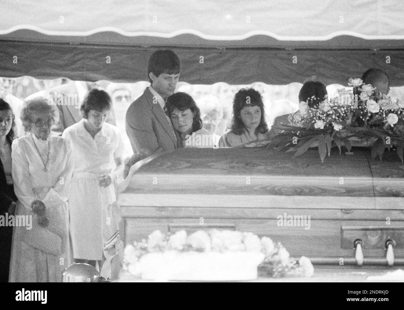 Michael and Sheree Ackerman embrace as they stand beside the casket of ...