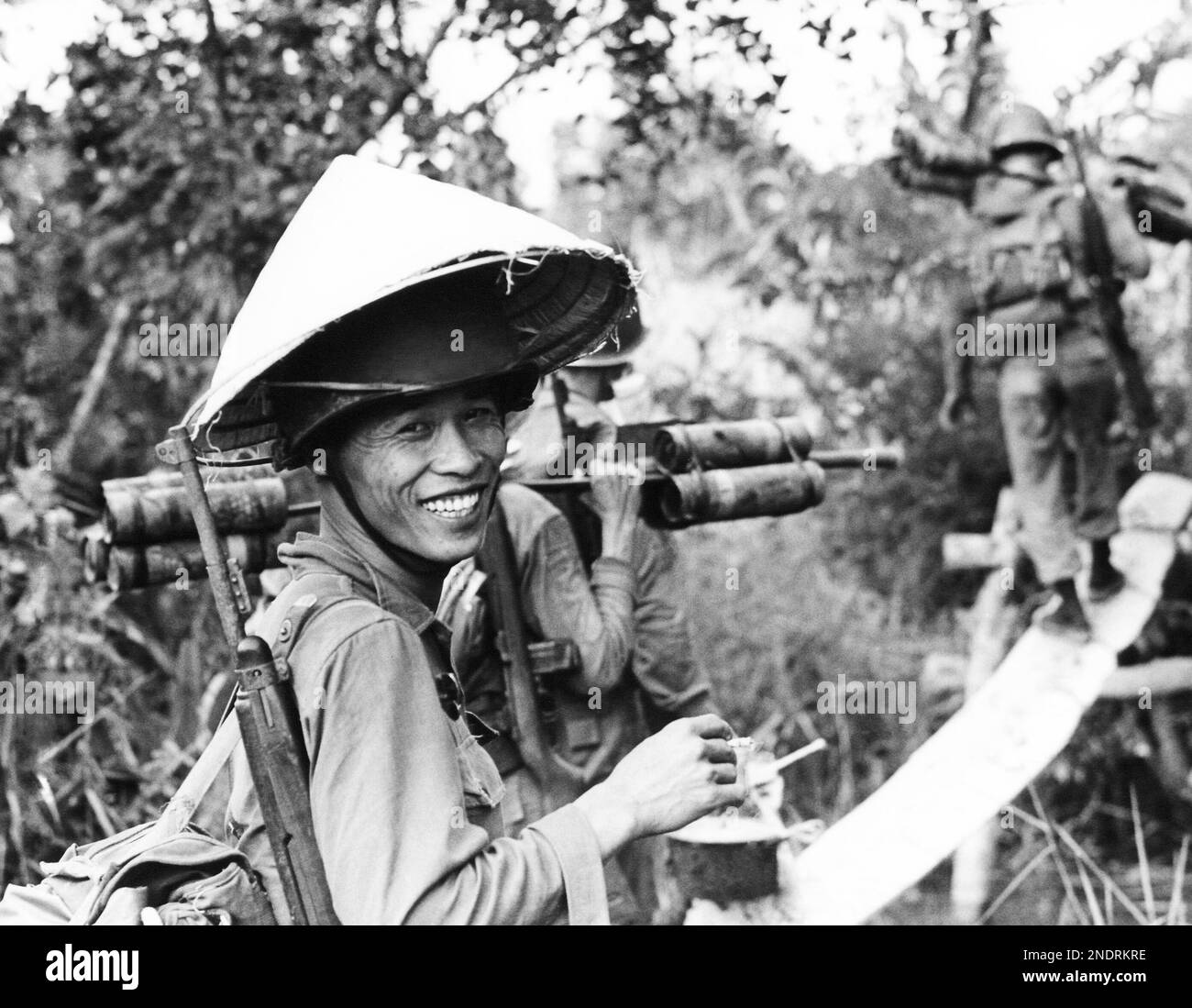 A Vietnamese soldier wears the traditional conical hat over his steel ...