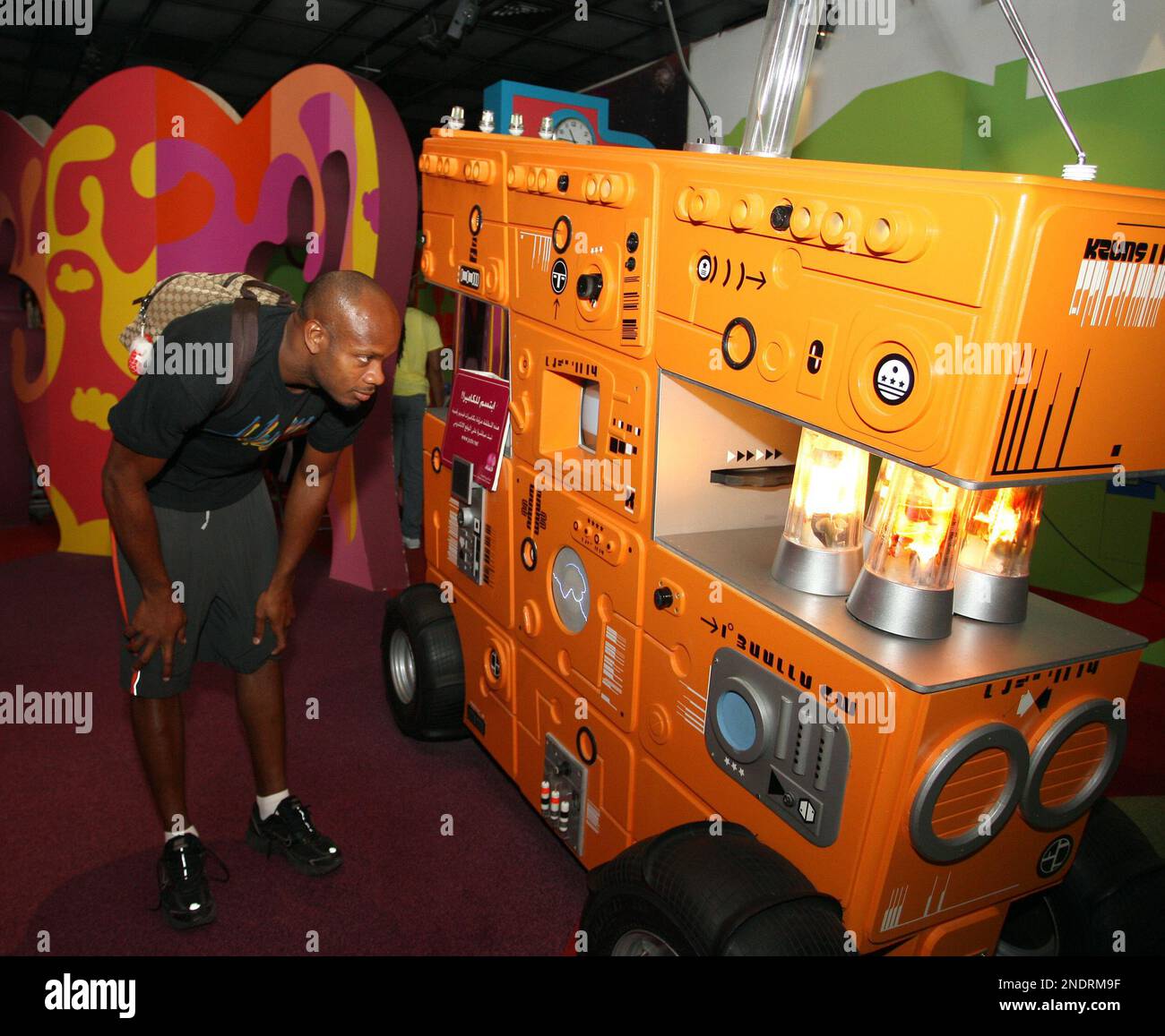 Jamaican sprinter Asafa Powell takes a look at an exhibit, during a ...