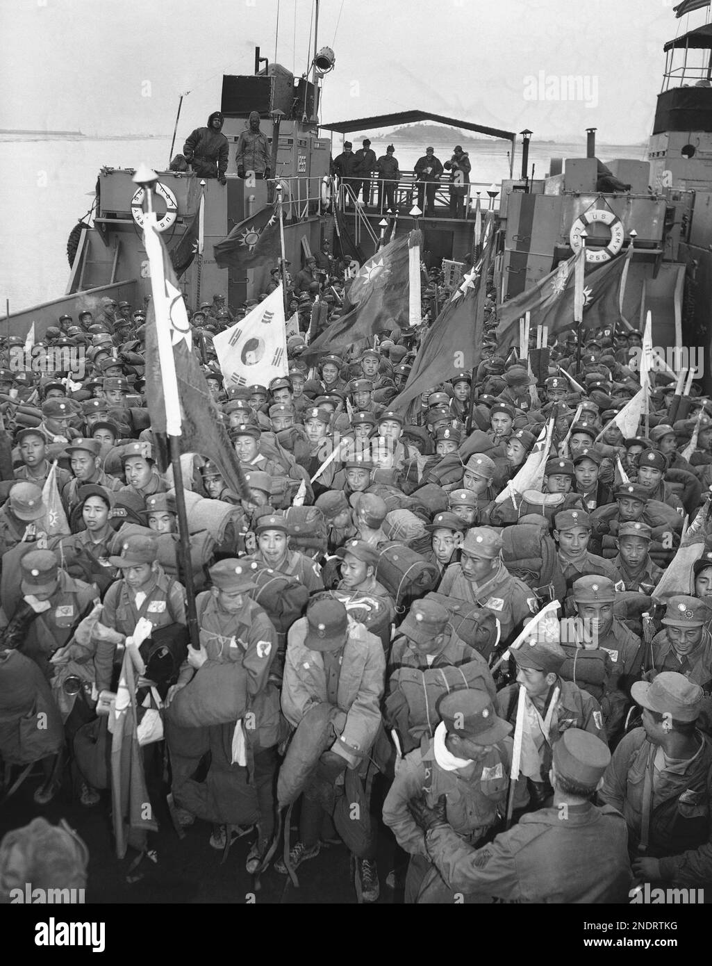 Chinese prisoners jam aboard a utility landing craft about to leave ...