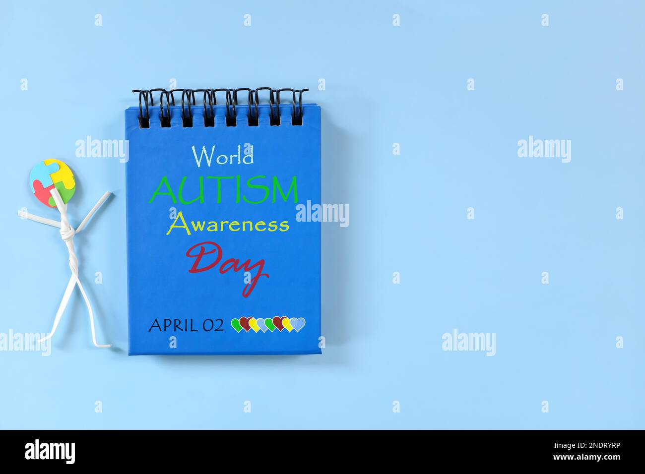 April 2 as World Autism Awareness Day date reminder on blue desk ...