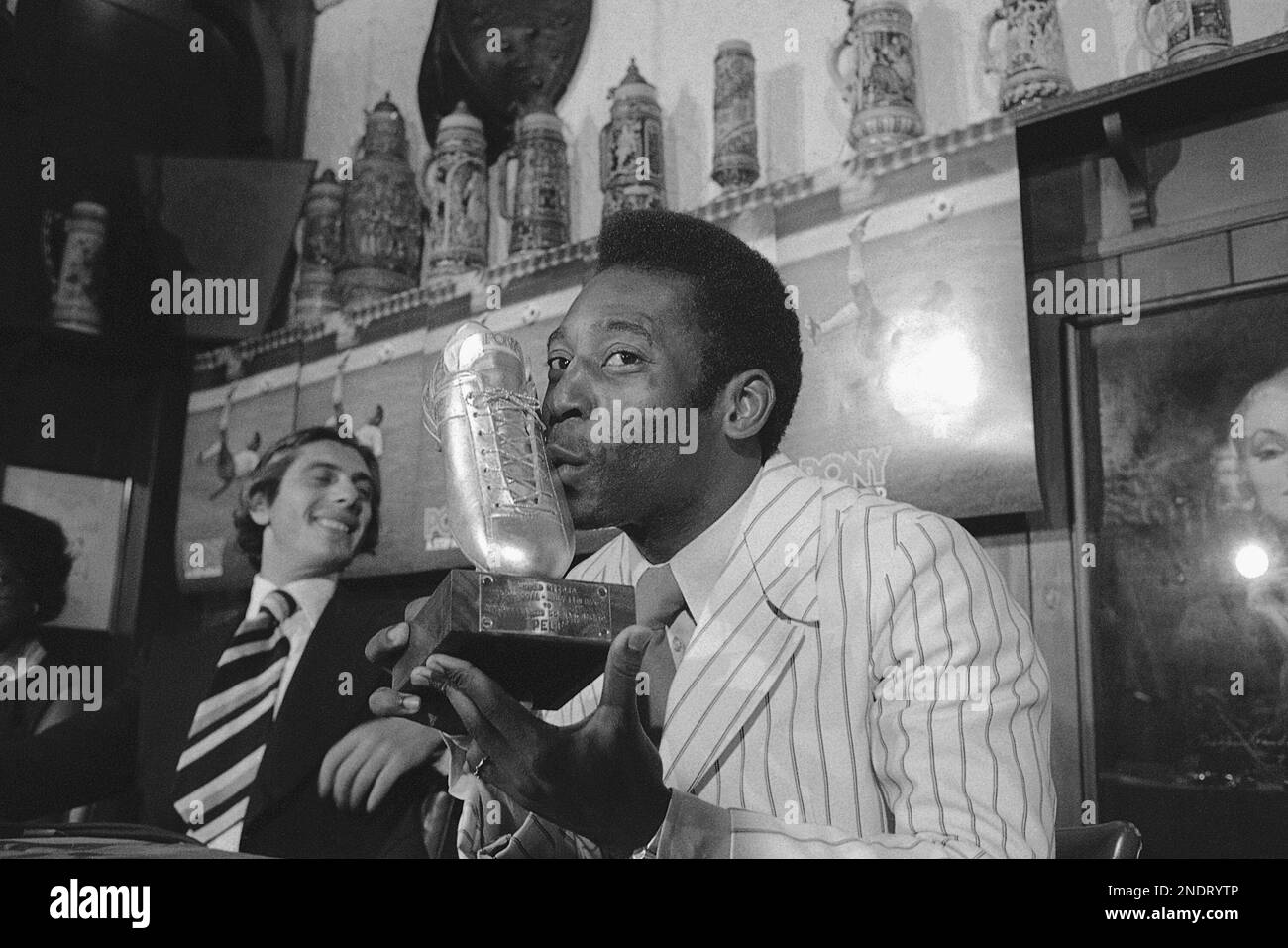 Soccer star Pele evokes laugh from Roberto Muller, left, as he kisses a ...