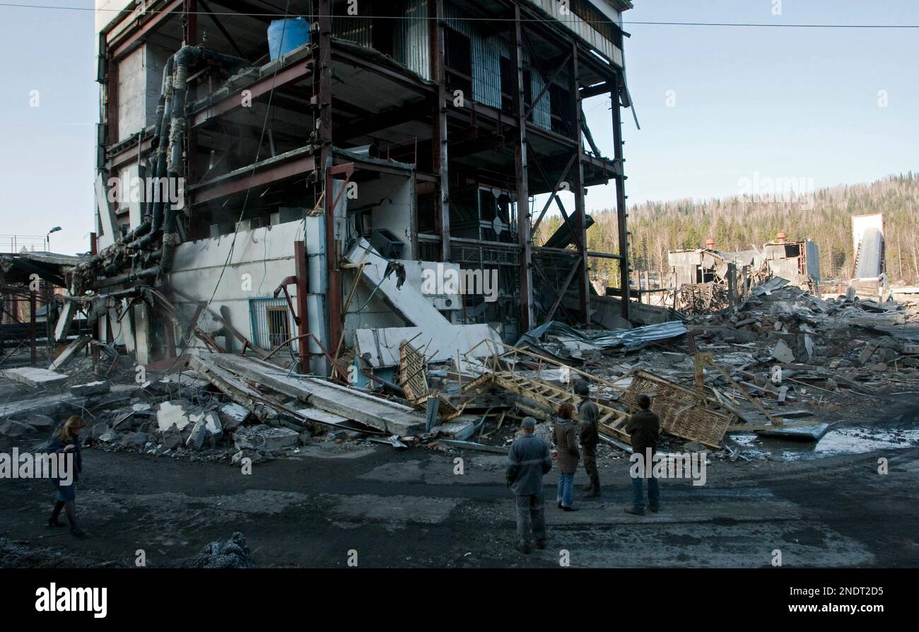 People walk around the building destroyed by the underground explosion ...