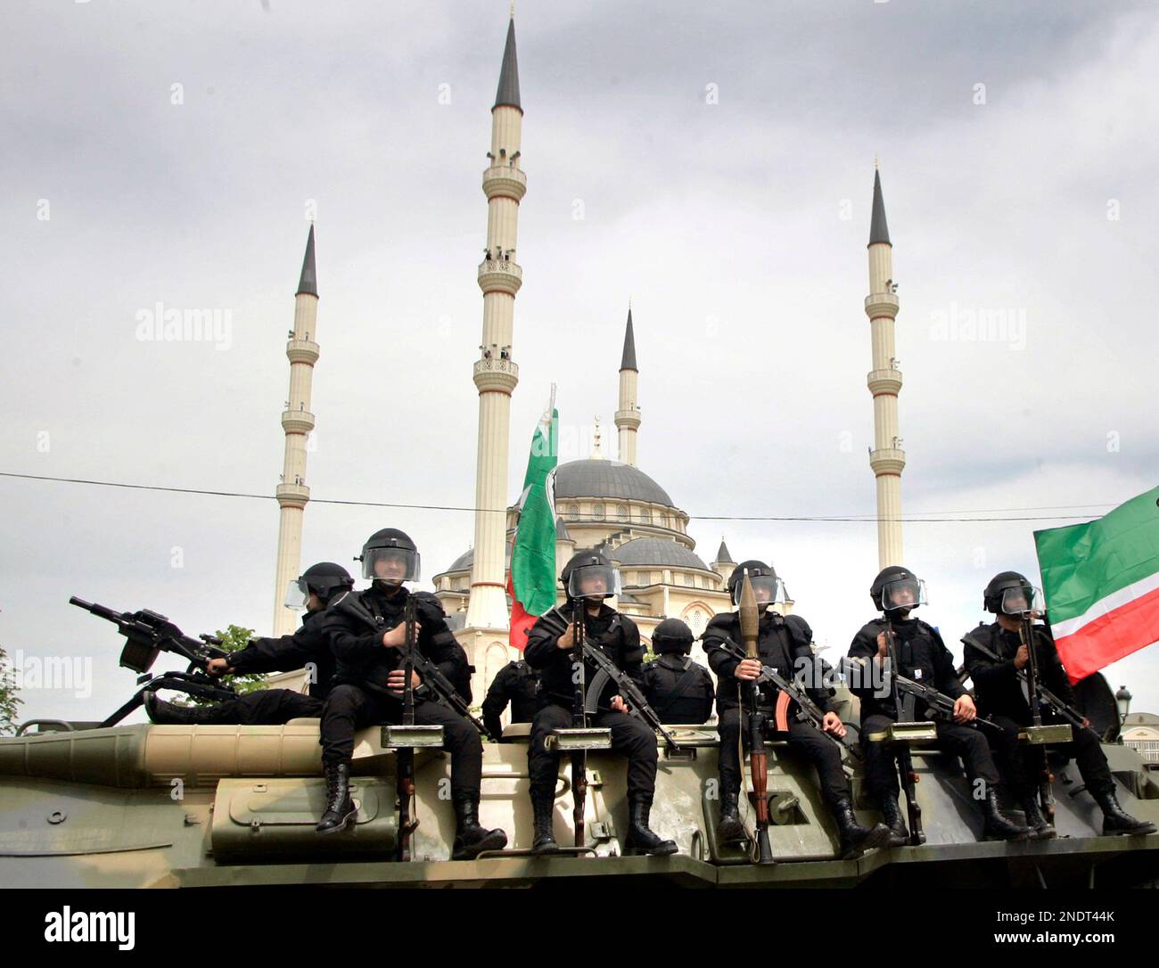 Heavily armed special forces officers ride atop an APC during the ...