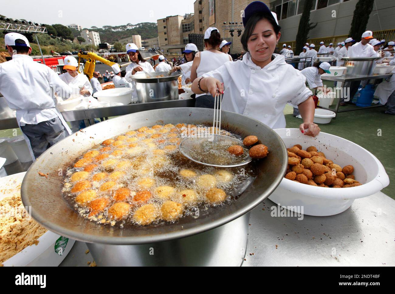 A Lebanese chef helps preparing a massive bowl of Falafel, a middle ...