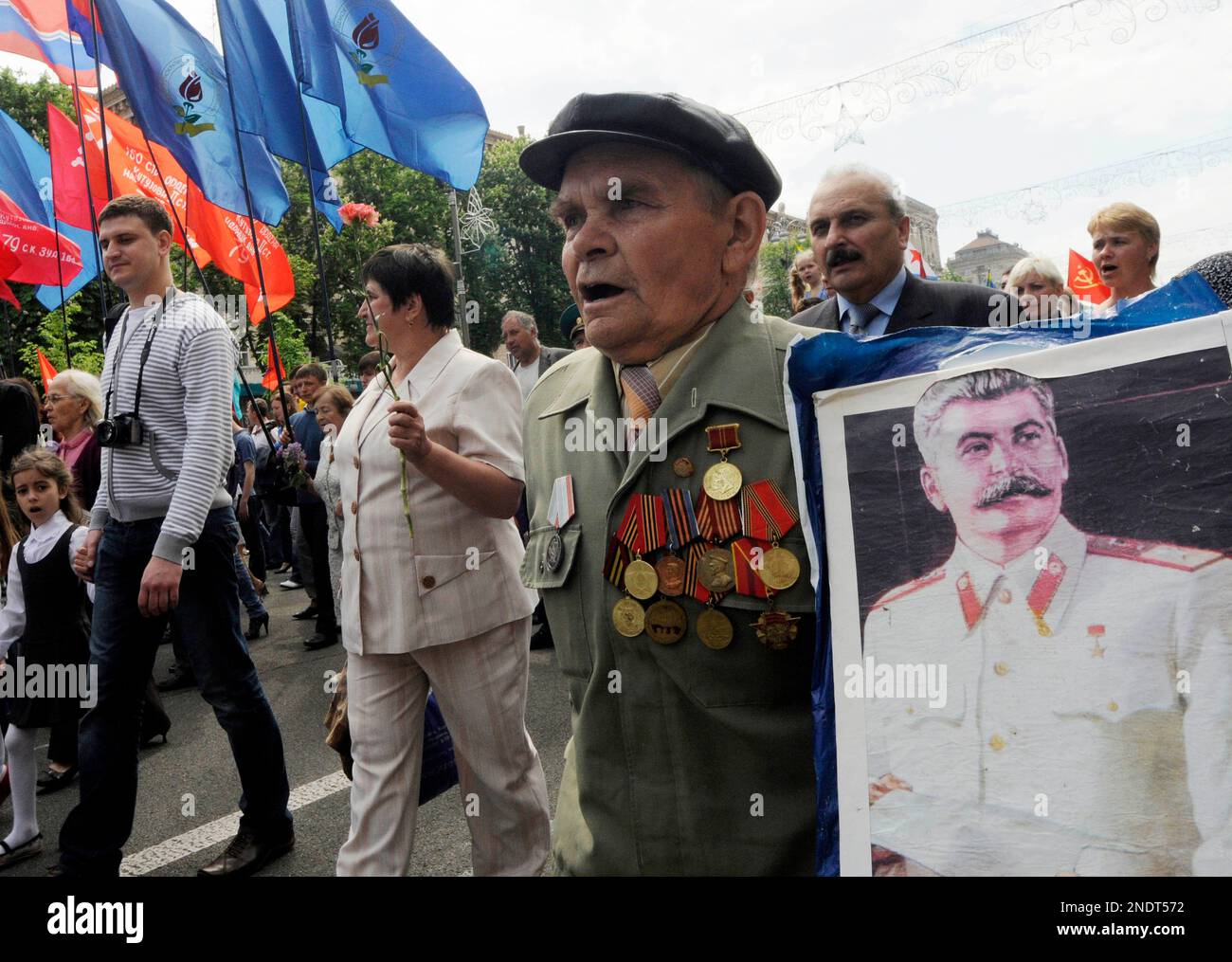 A World War II veteran carries a portrait of former Soviet dictator ...