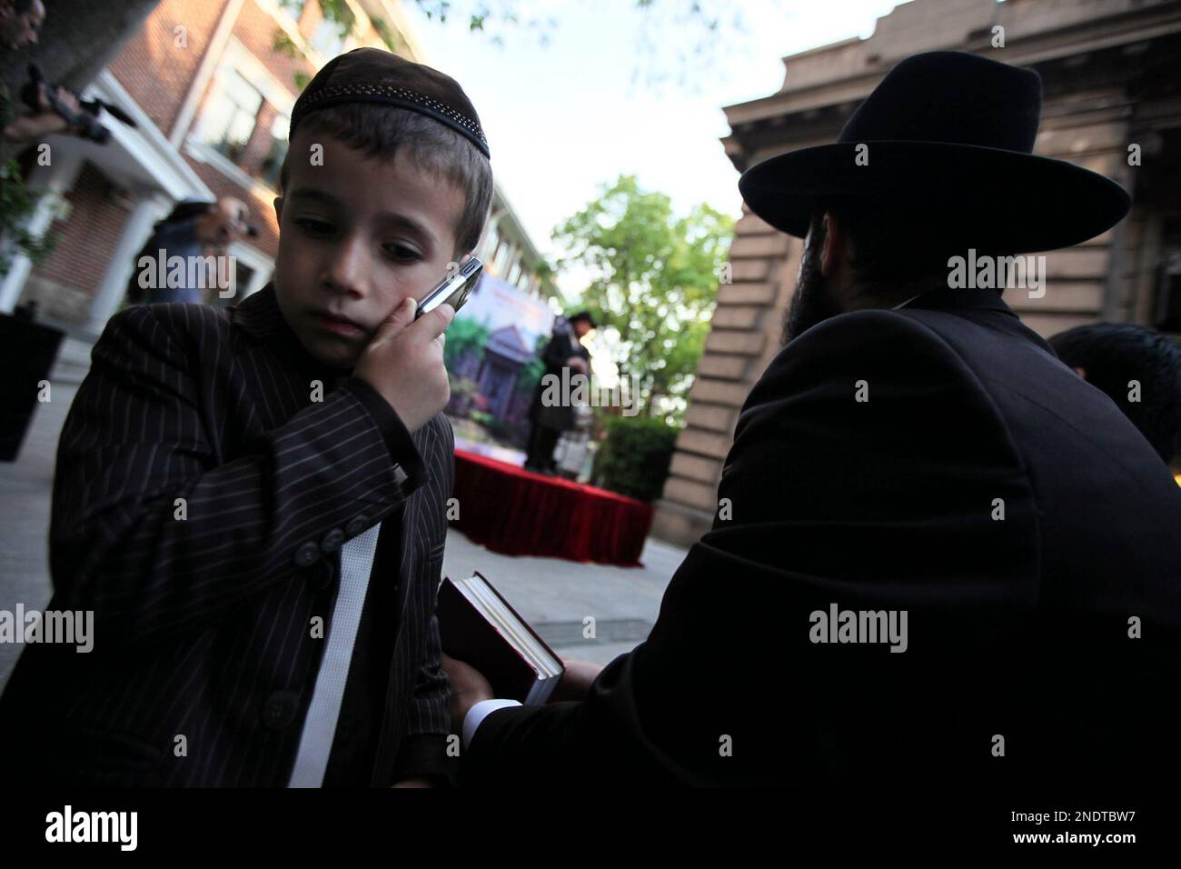 A Jewish boy makes a phone call during the opening ceremony of Ohel ...