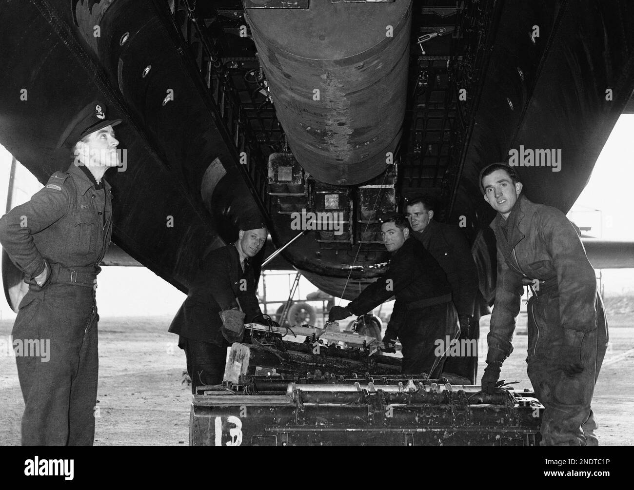 Loading up a case of incendiary bombs alongside a block buster bomb, in ...
