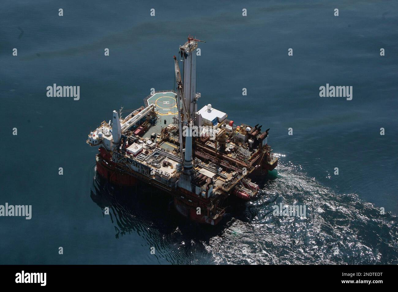 A deep water drilling rig churns towards the rig explosion site of the ...