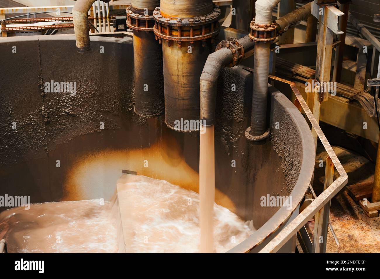 Pouring liquid into huge bath of modern floatation machine Stock Photo ...