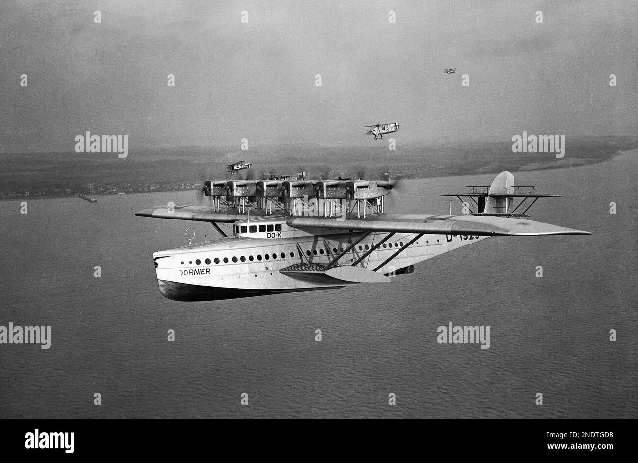 An escort of planes bring in the German flying boat, Dornier Do X, as ...