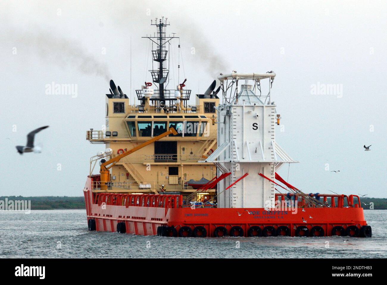 The barge Joe Griffin sails down a channel on its way to the Gulf of ...