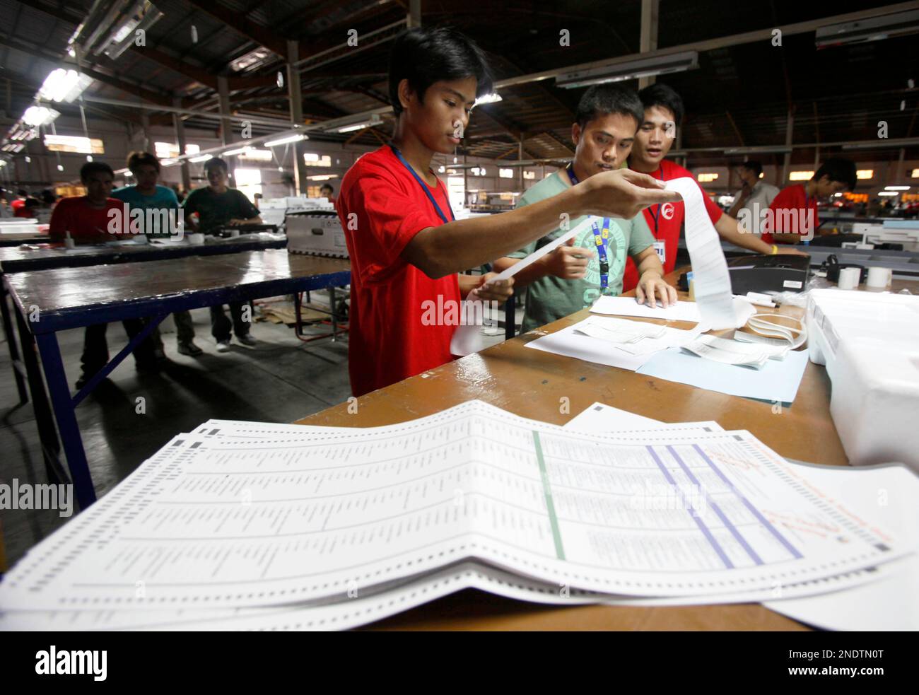 Workers check the print out from the PCOS (Precinct Count Optical Scan ...