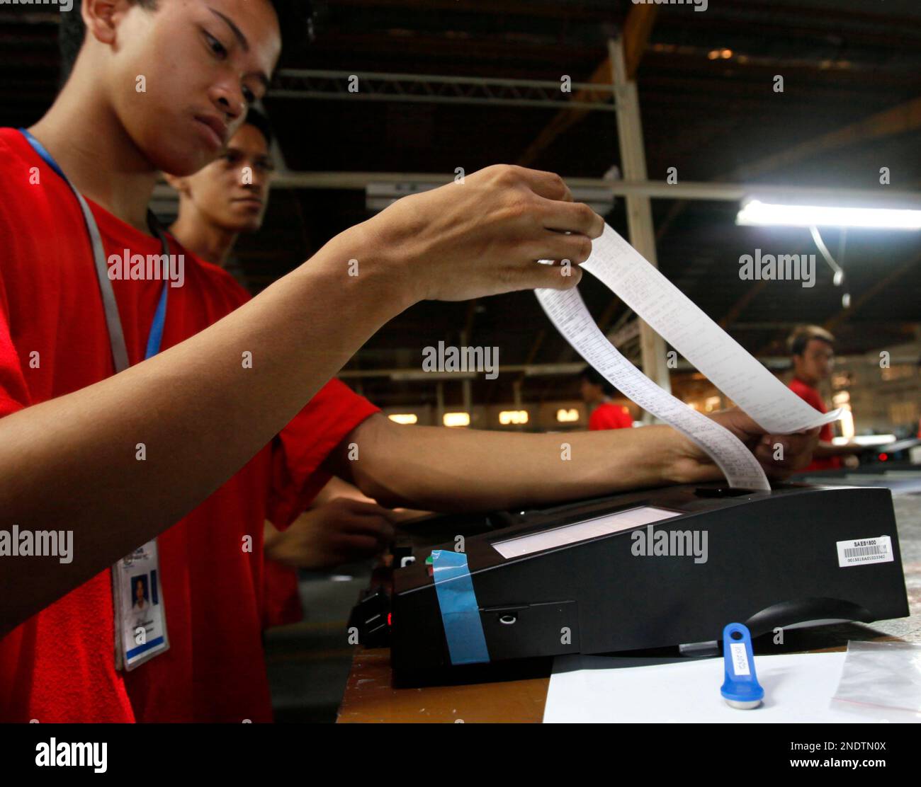 A worker checks the print out from the PCOS (Precinct Count Optical ...