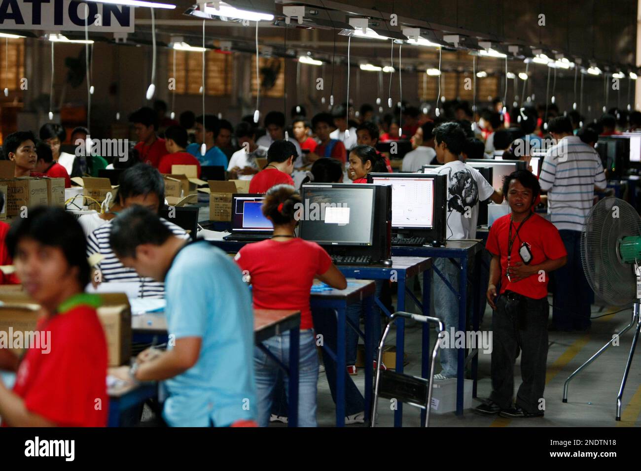 Workers check the PCOS (Precinct Count Optical Scan) machines as they ...