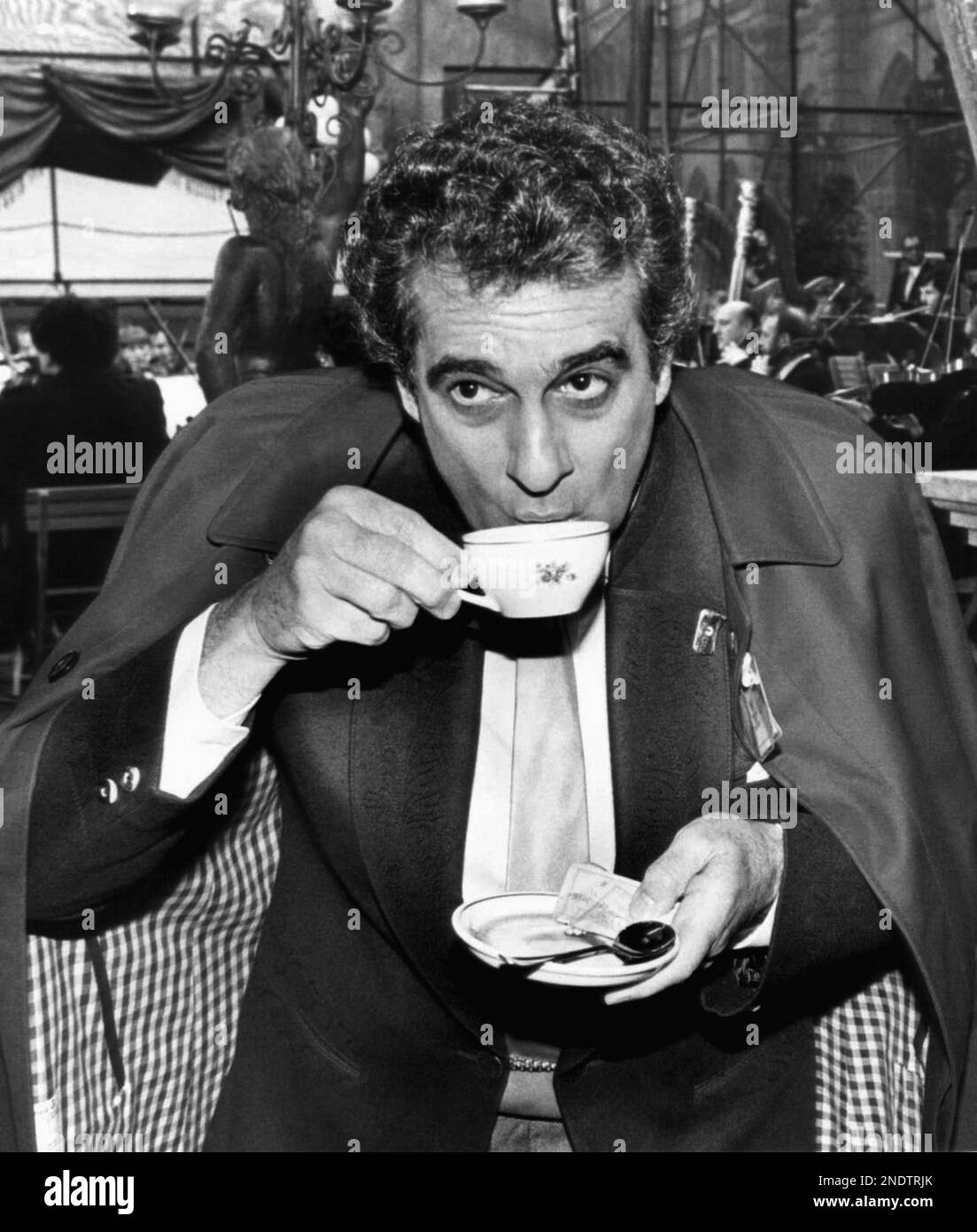 Opera singer Placido Domingo sips from a cup of coffee during ...
