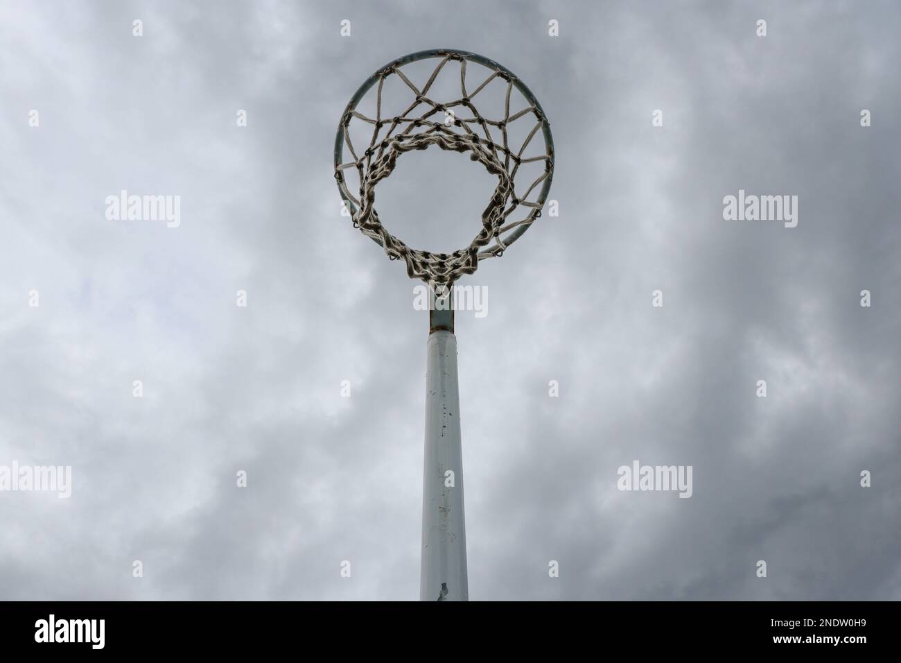 A low angle shot of a netball hoop under the overcast sky Stock Photo ...
