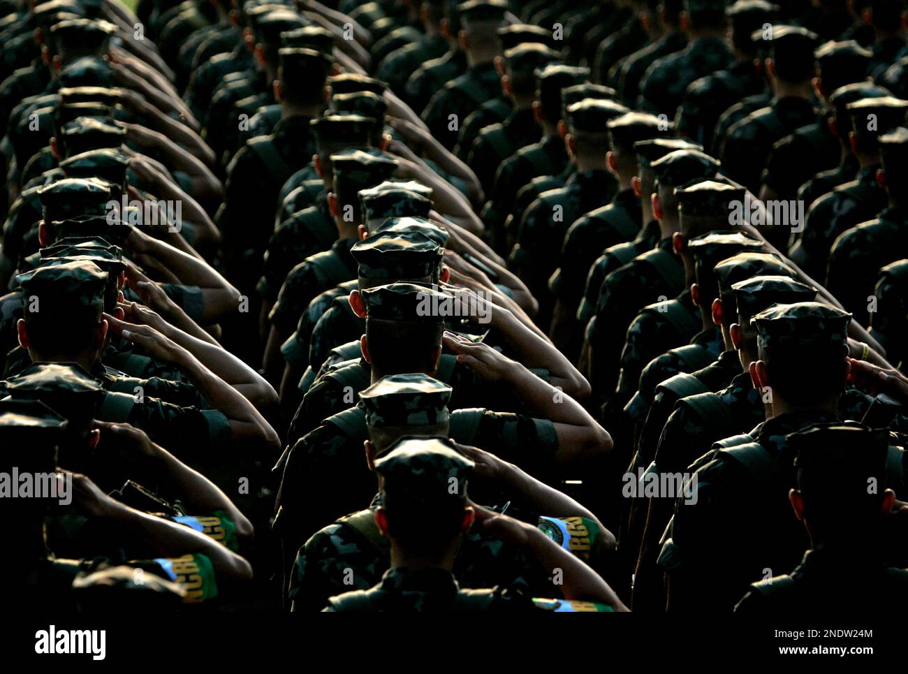 Filipino troopers salute before the flag during rites at Camp Aguinaldo ...