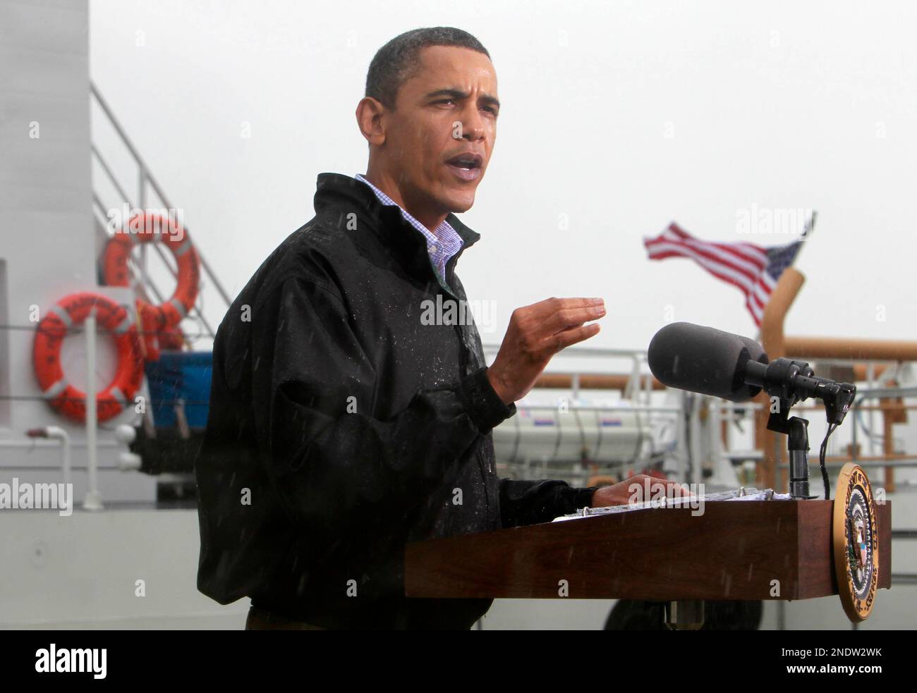 President Barack Obama, standing in the rain, makes a statement to ...