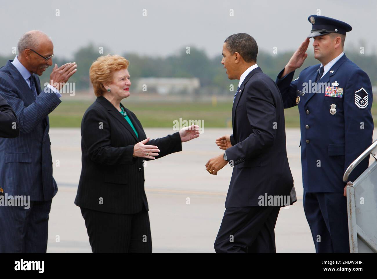 President Barack Obama is greeted by Sen. Debbie Stabenow, D-Mich., and ...