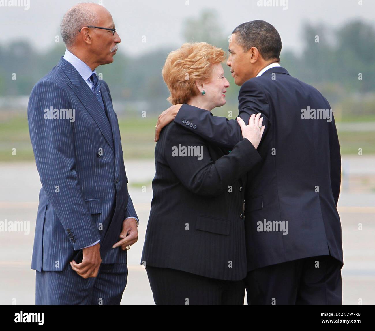 President Barack Obama is greeted by Sen. Debbie Stabenow, D-Mich., and ...