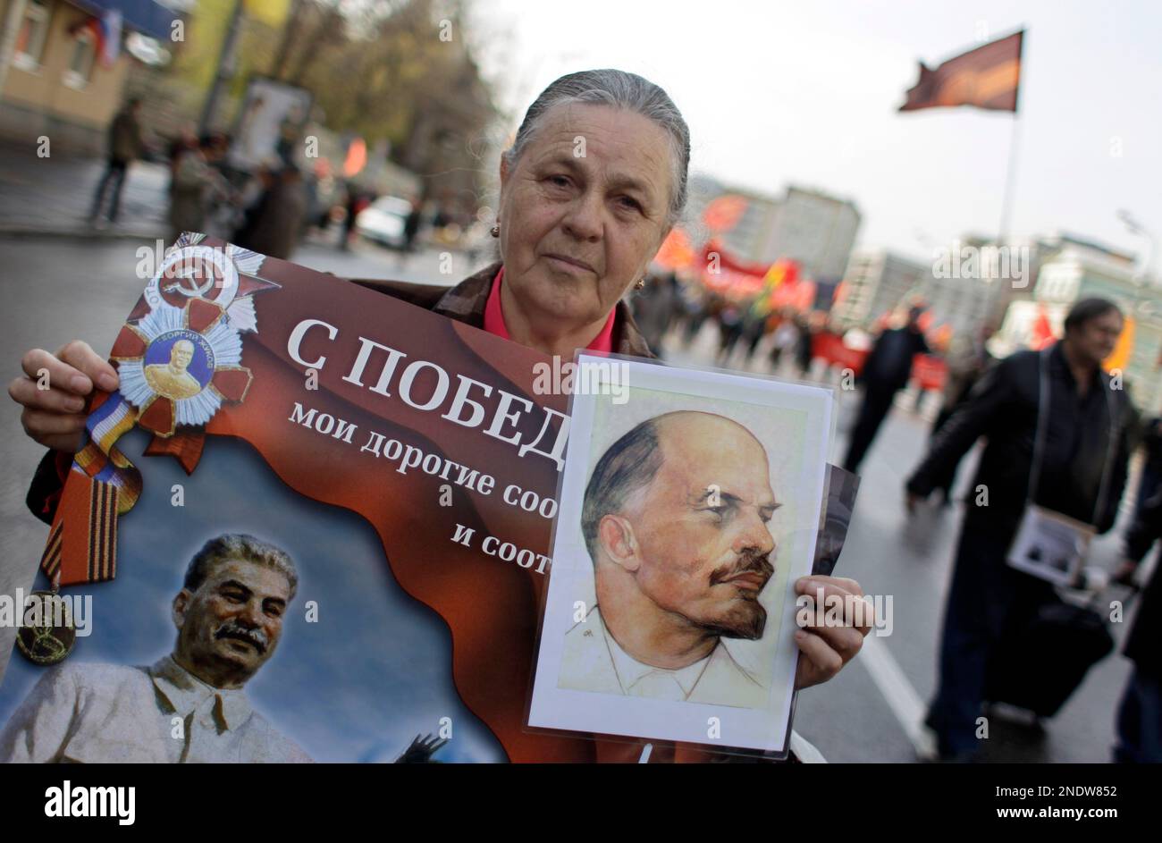 A communist party supporter carries portraits of Soviet dictator Josef ...