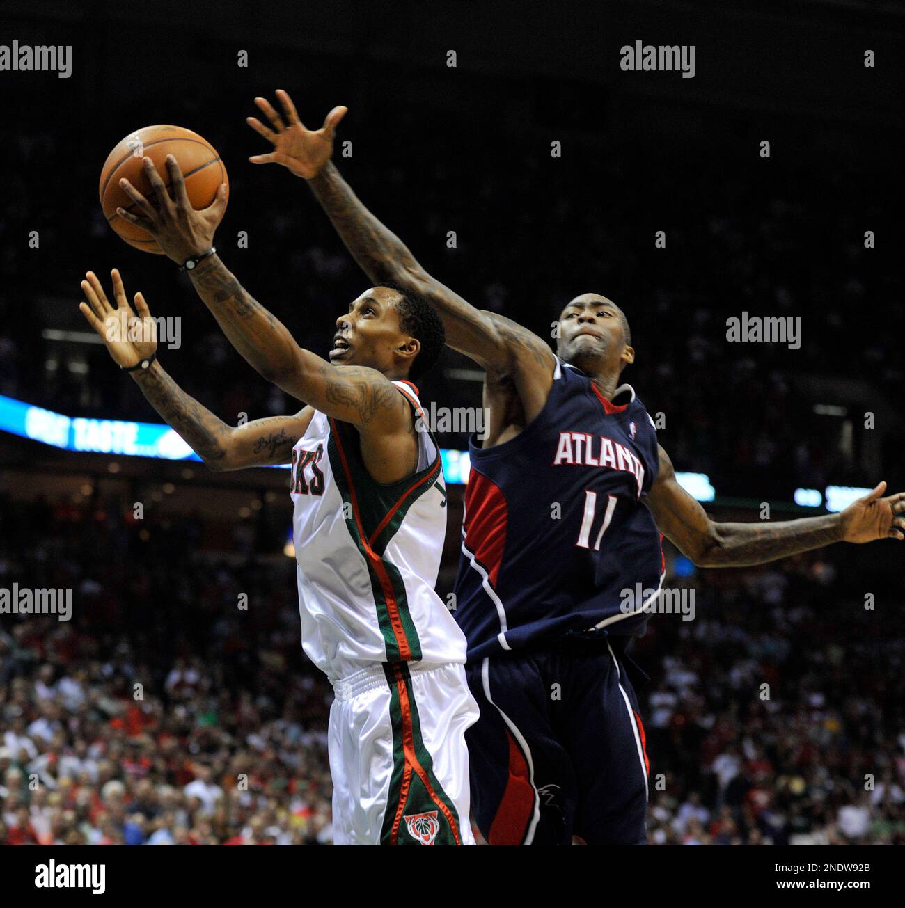 Milwaukee Bucks' Brandon Jennings, left, drives to the basket as ...
