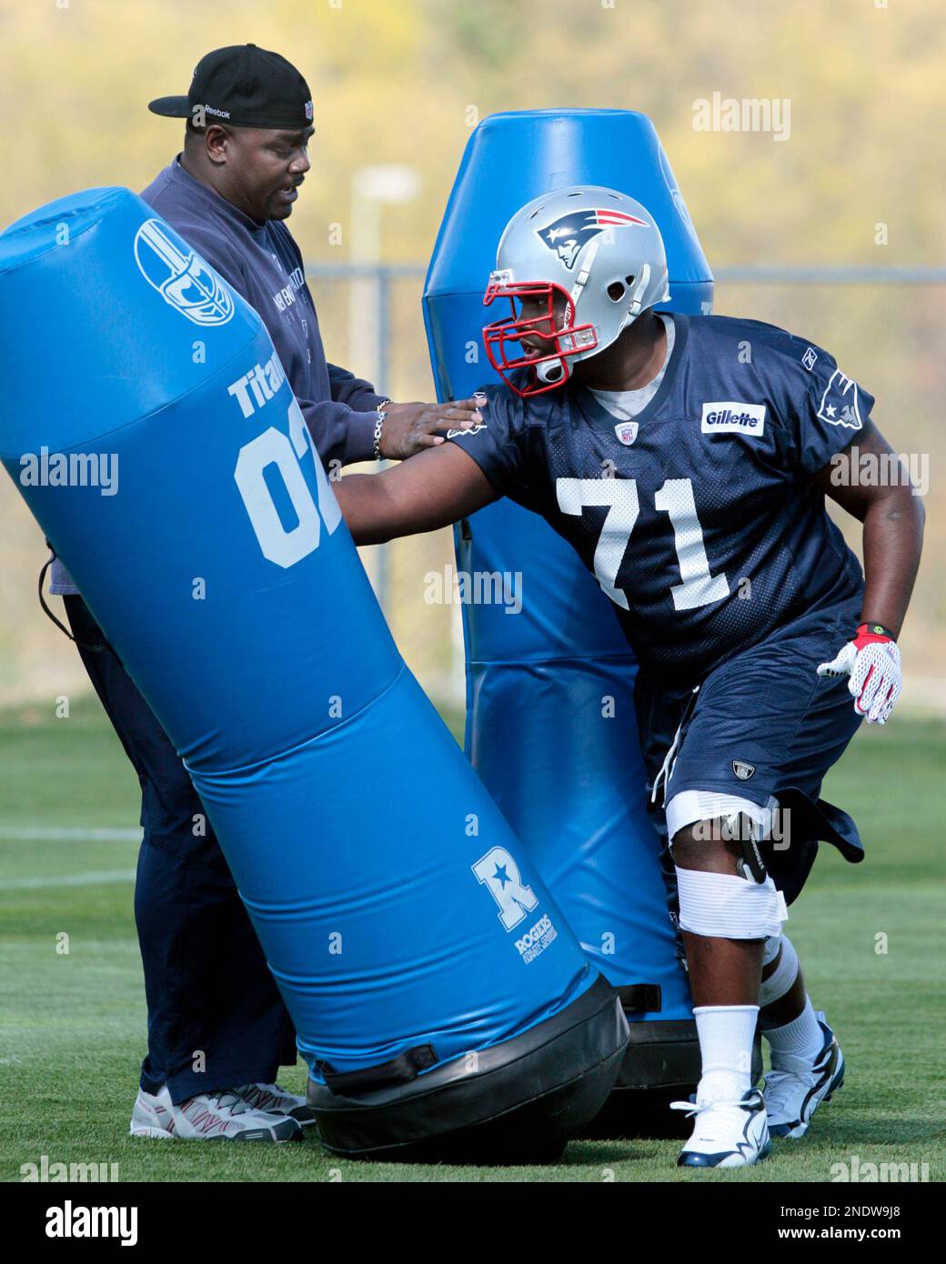 Defensive line coach Pepper Johnson instructs linesman Brandon Deaderic ...