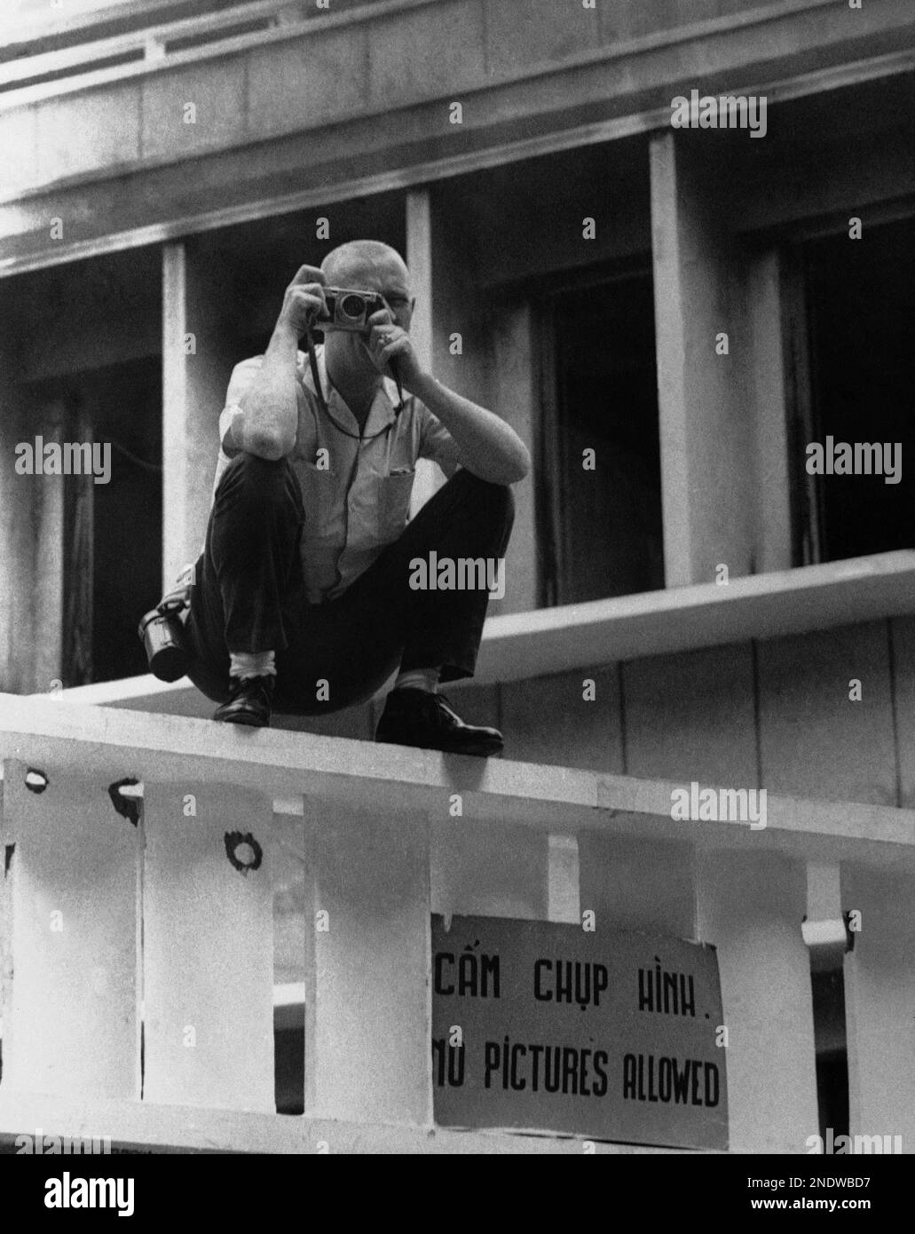 An unidentified newsman covering the Saigon coup d’etat ignores the ...