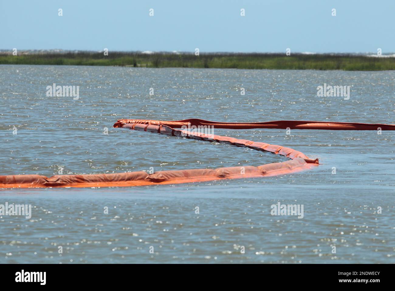 An oil containment boom is deployed behind Coast Guard Island near ...