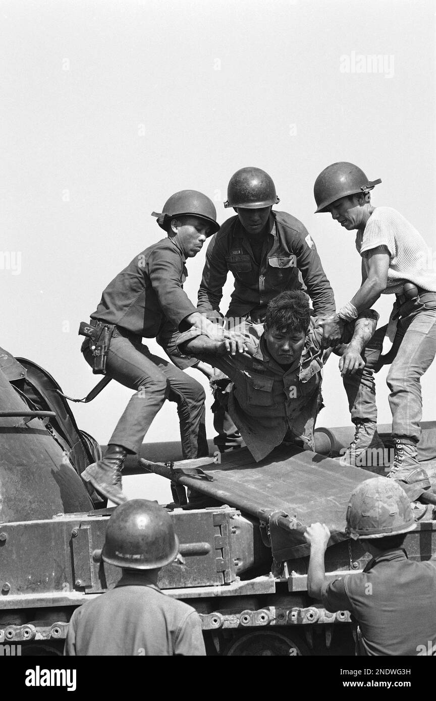 A wounded South Vietnamese soldier is pulled from his tank onto a ...