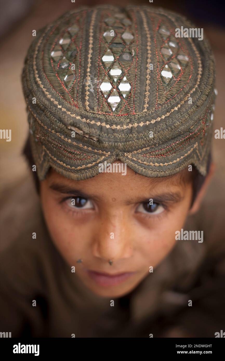 A Pakistani child looks on outside a daily class which teaches how to ...
