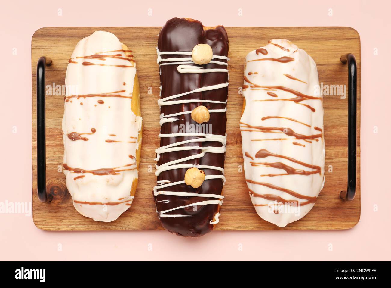 Board with delicious eclairs on pink background Stock Photo - Alamy