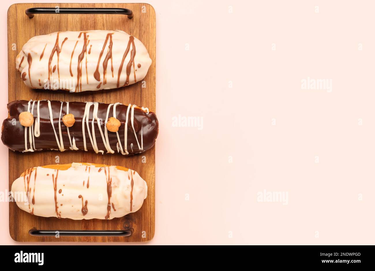 Board with delicious eclairs on pink background Stock Photo - Alamy