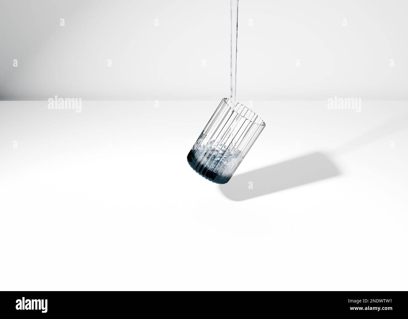 This picture shows a clear glass object hanging upside down by a thin ...