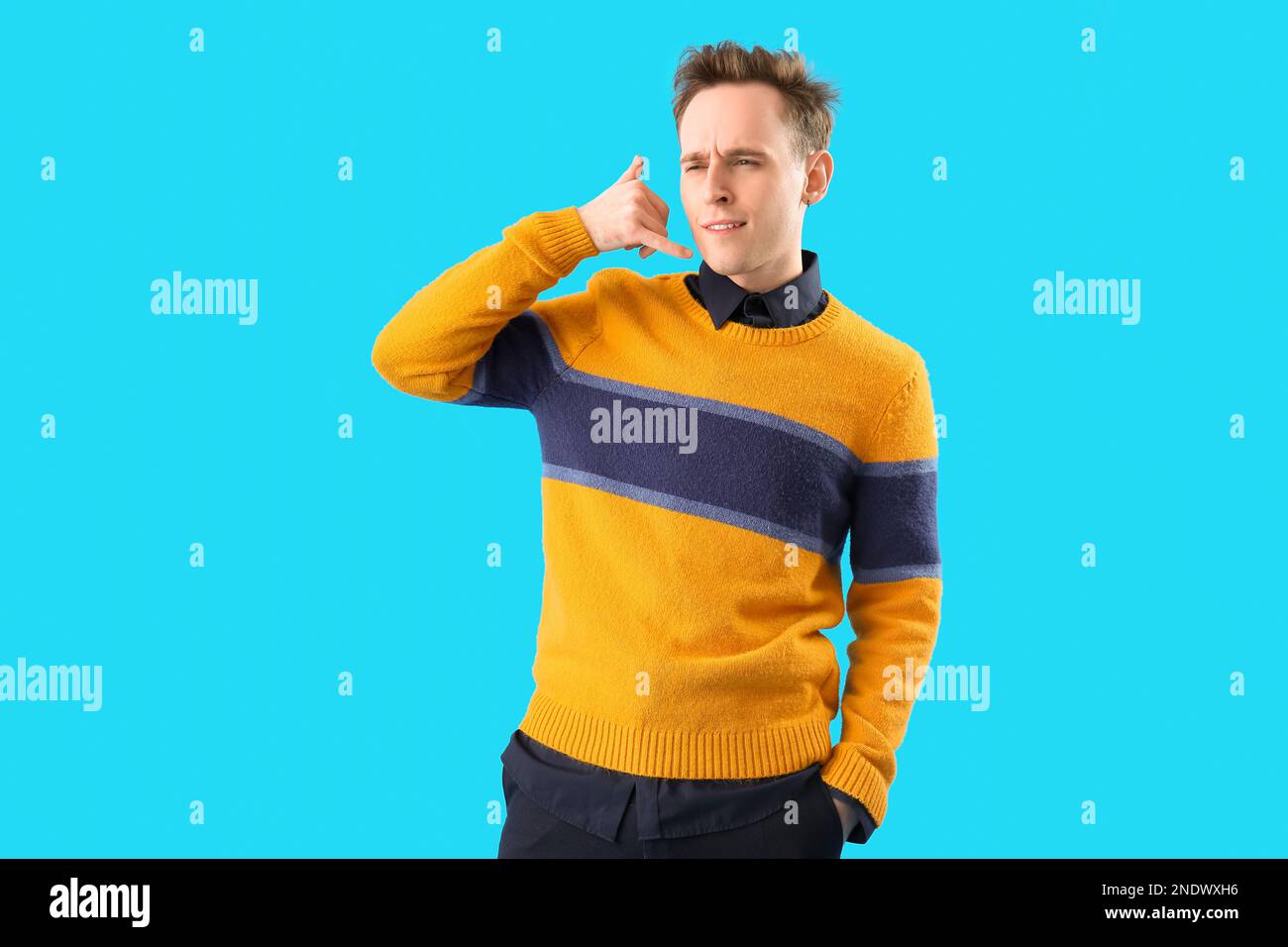 Cool young man showing "call me" gesture on blue background Stock Photo ...
