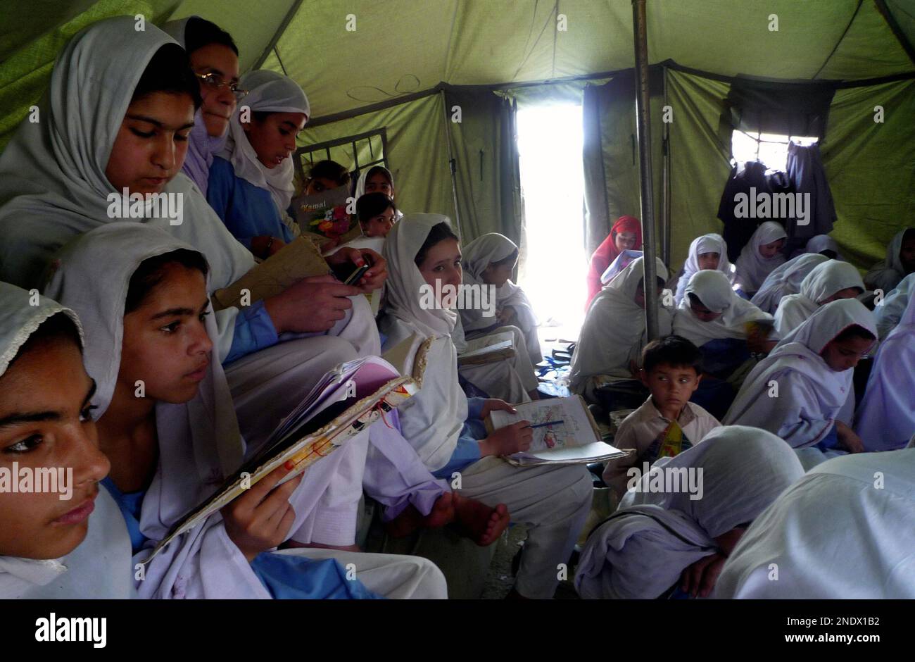 Pakistani female students study in a make-shift classroom set up in a ...