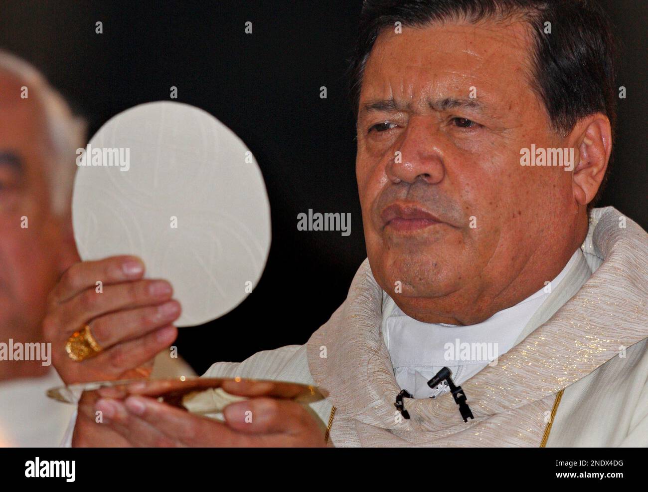 Mexican Cardinal Norberto Rivera looks at the host during a Mass at the ...