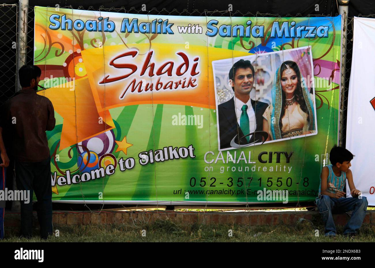 A Pakistani worker fixes a greeting banner with the pictures of newly ...