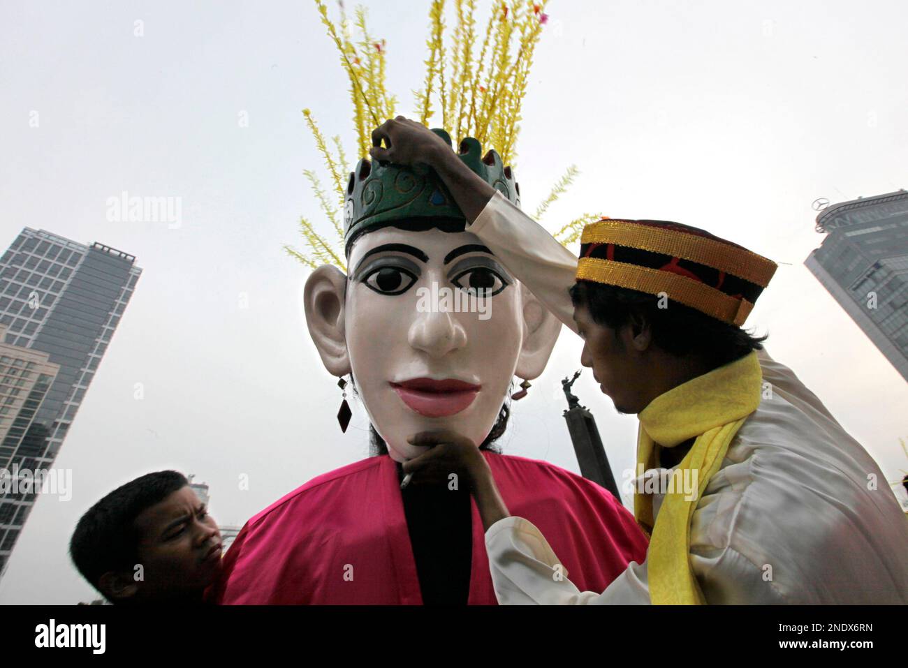 Indonesian men prepare a traditional giant puppet called "ondel-ondel" during a festival marking ...