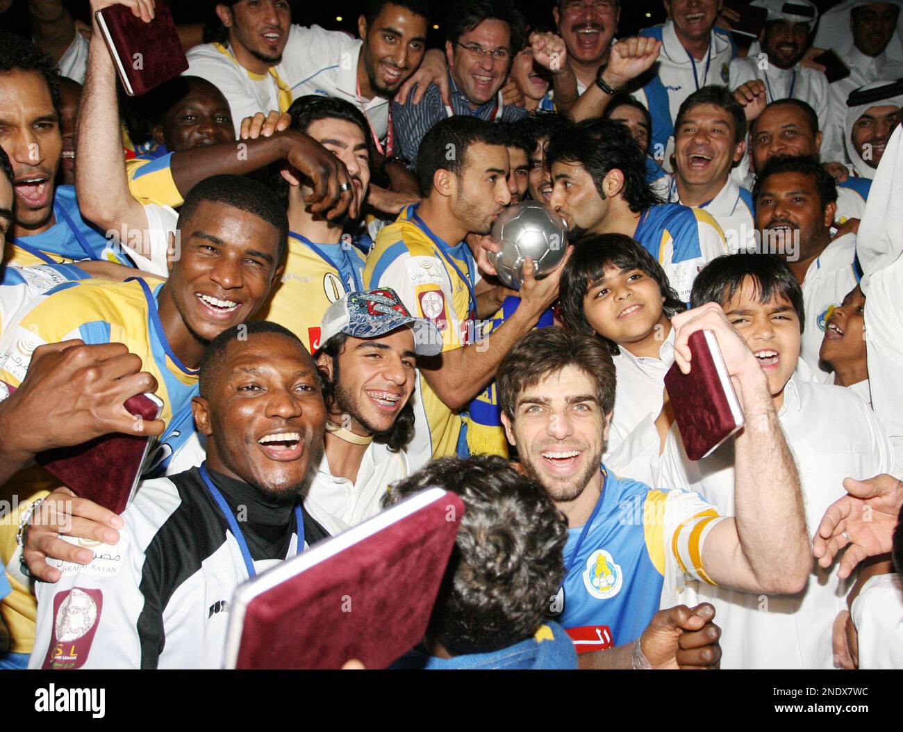 Qatari Al-Gharrafa club players pose with the trophy after winning the ...