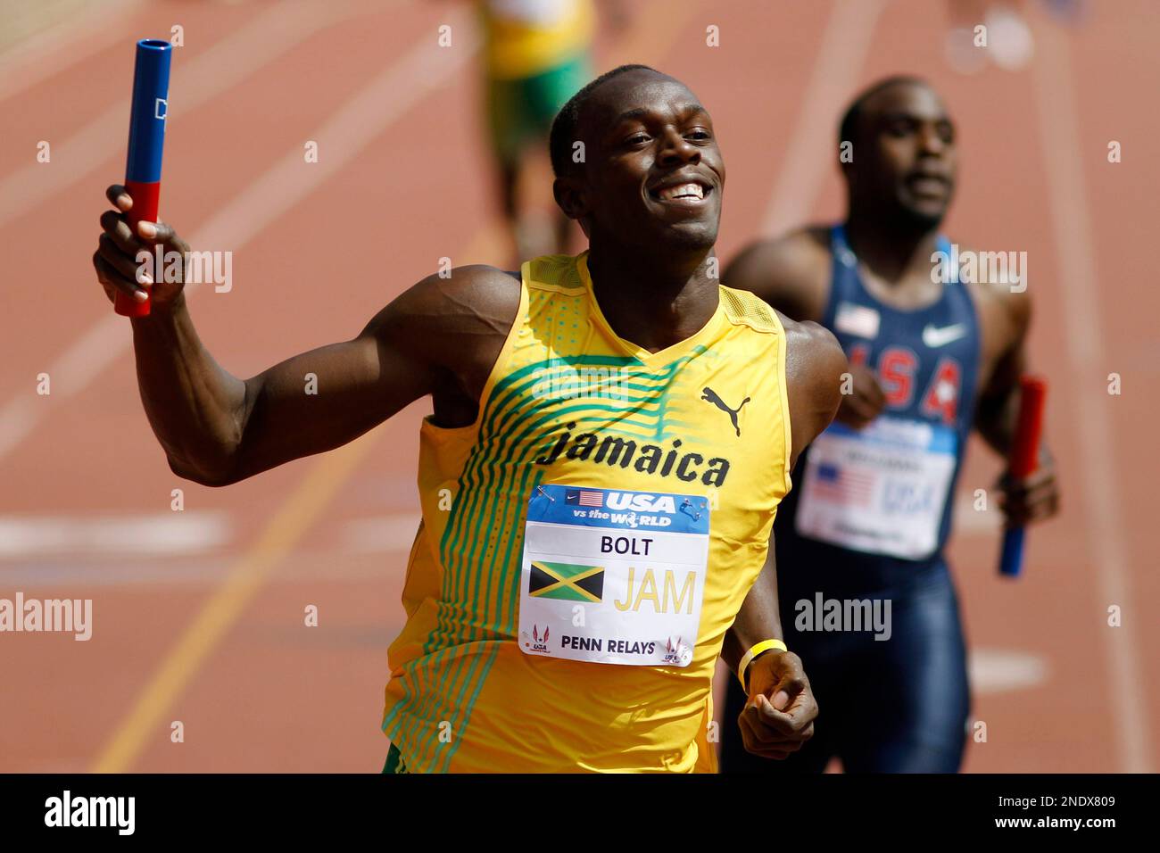 Jamaican sprinter Usain Bolt smiles after crossing the finish line to ...