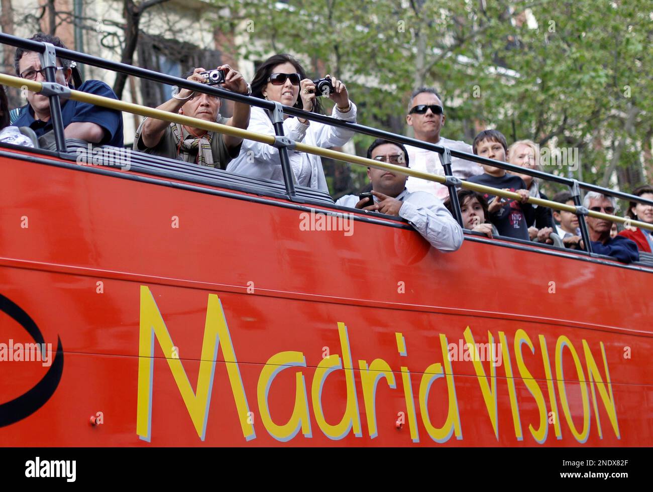 Turists take photos from atop a double-decker bus of a demonstration by ...