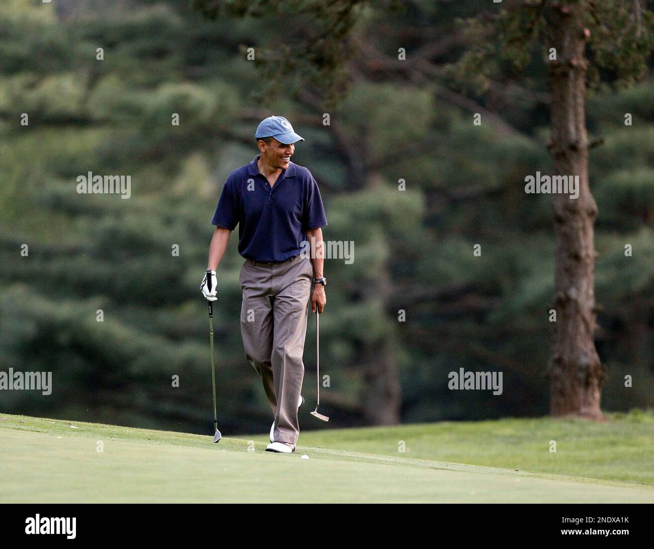 President Barack Obama smiles as he walks onto the 10th green of the ...