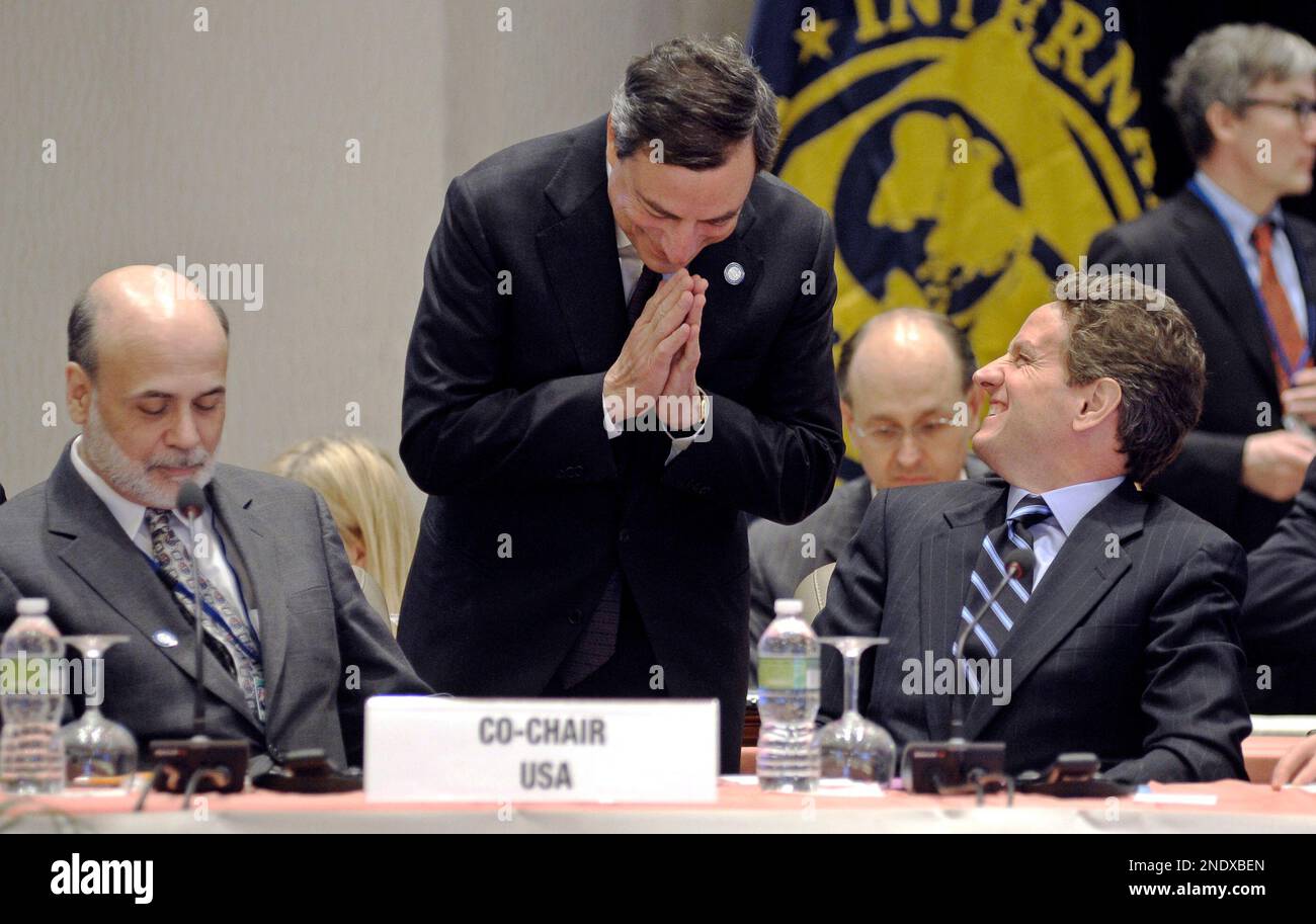 US Federal Reserve Chairman Ben Bernanke, left, looks over documents ...