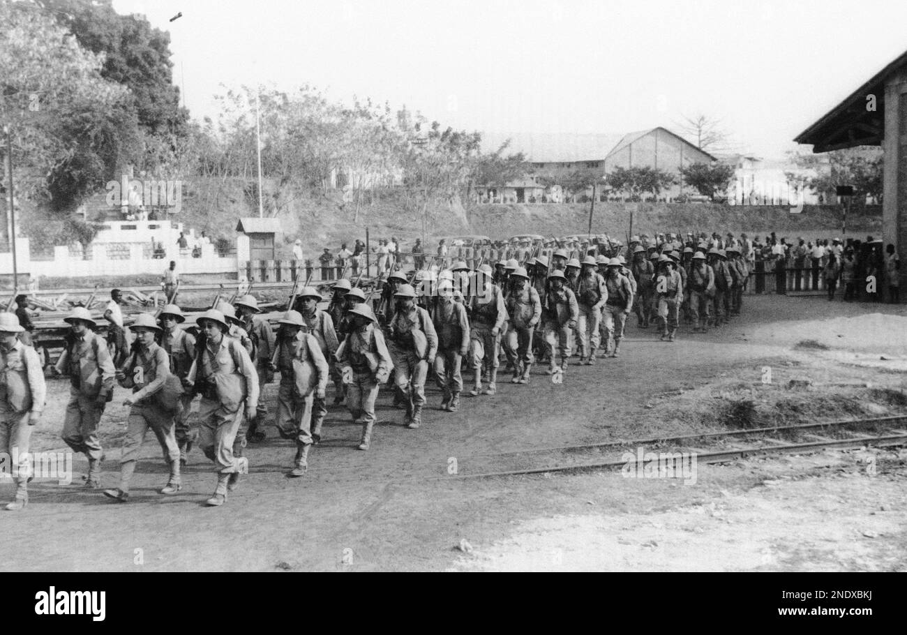 U.S. troops march through a street at Leopoldville, Belgian Congo ...