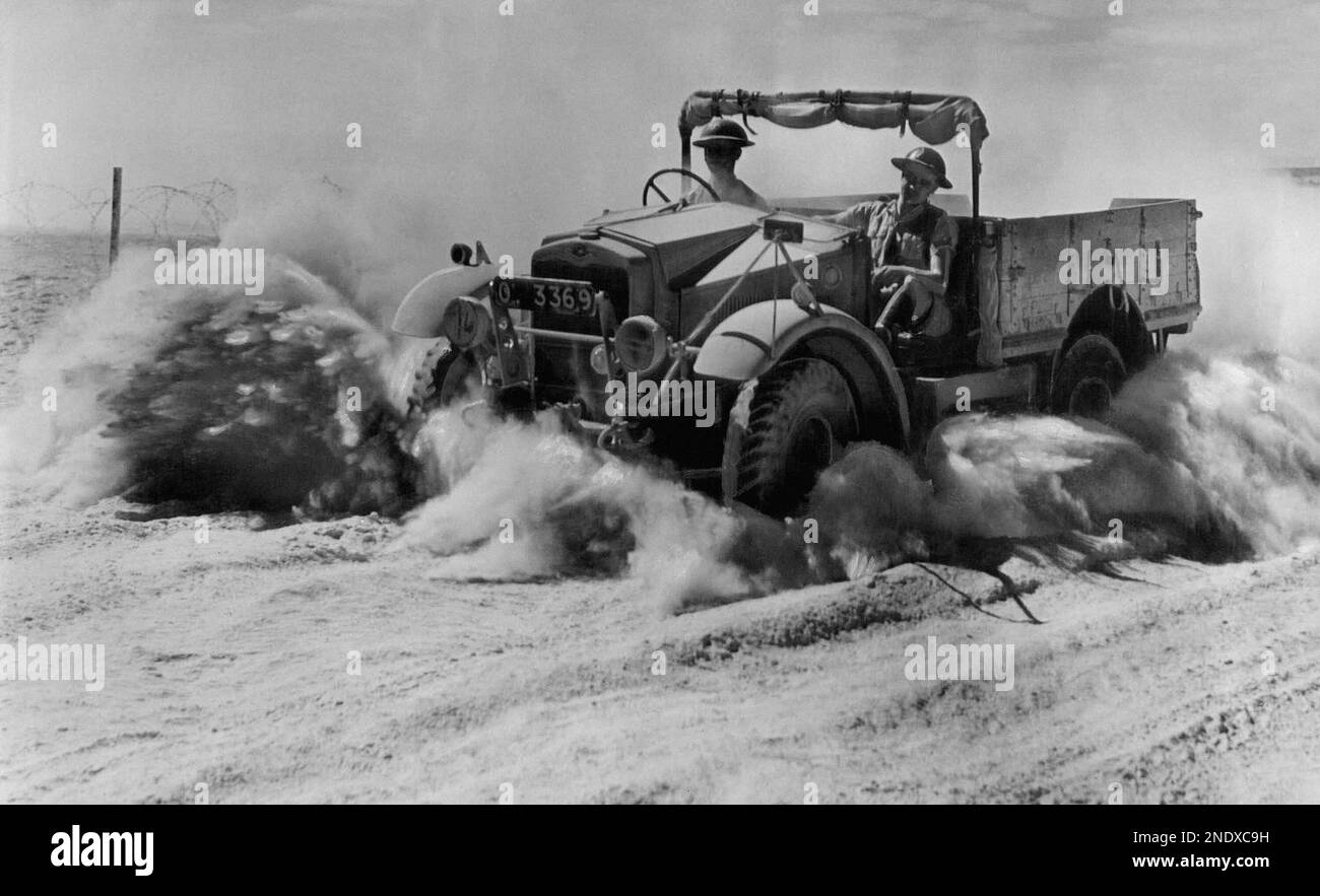 British military truck, throwing clouds of dust as it roars down a ...