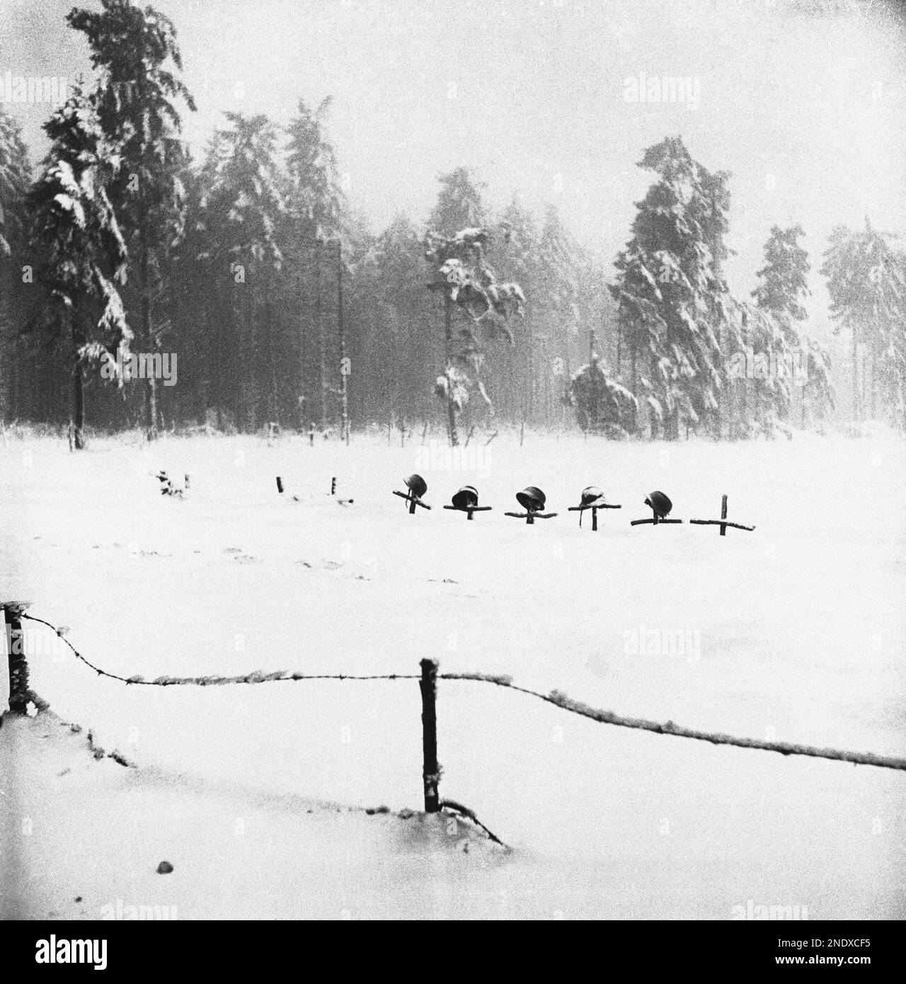 Crude wooden crosses, some of them with steel helmets affixed, mark the ...