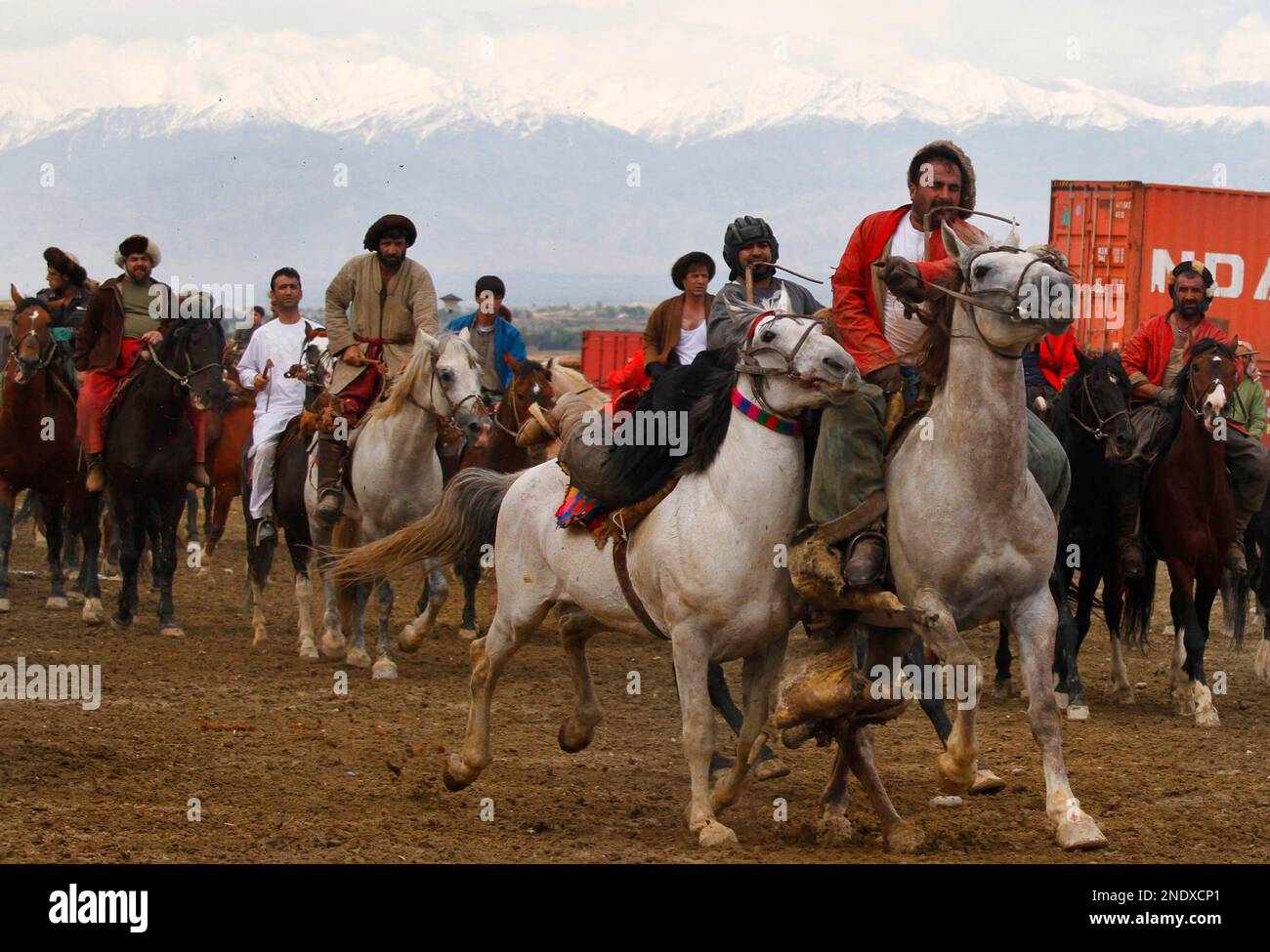 Buzkashi players battle for control of a goat carcass during a match in ...